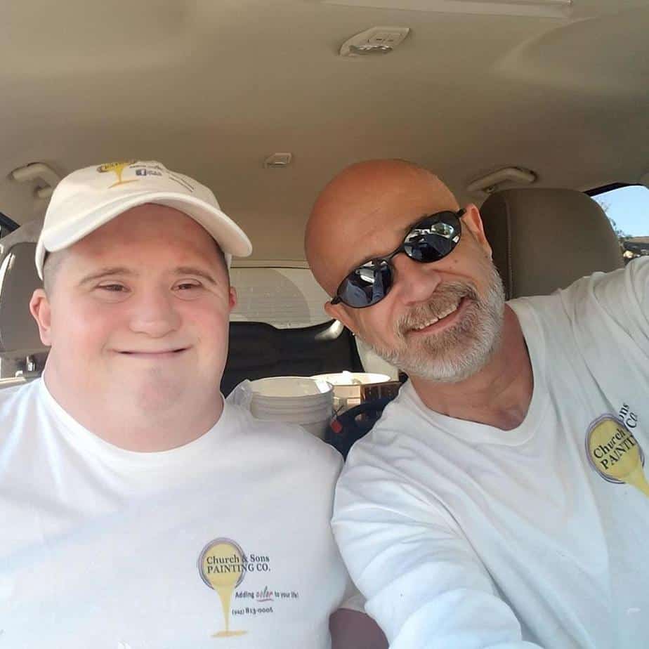 Son with Down syndrome comforts dad having an emotional breakdown