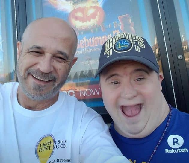 Son with Down syndrome comforts dad having an emotional breakdown