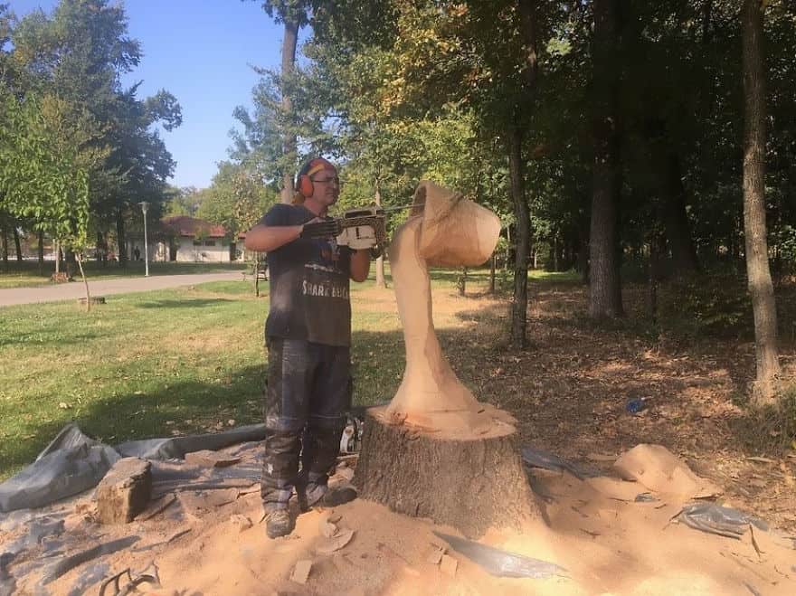 Chainsaw artist turns rotten tree stump into illusion of bucket pouring ...
